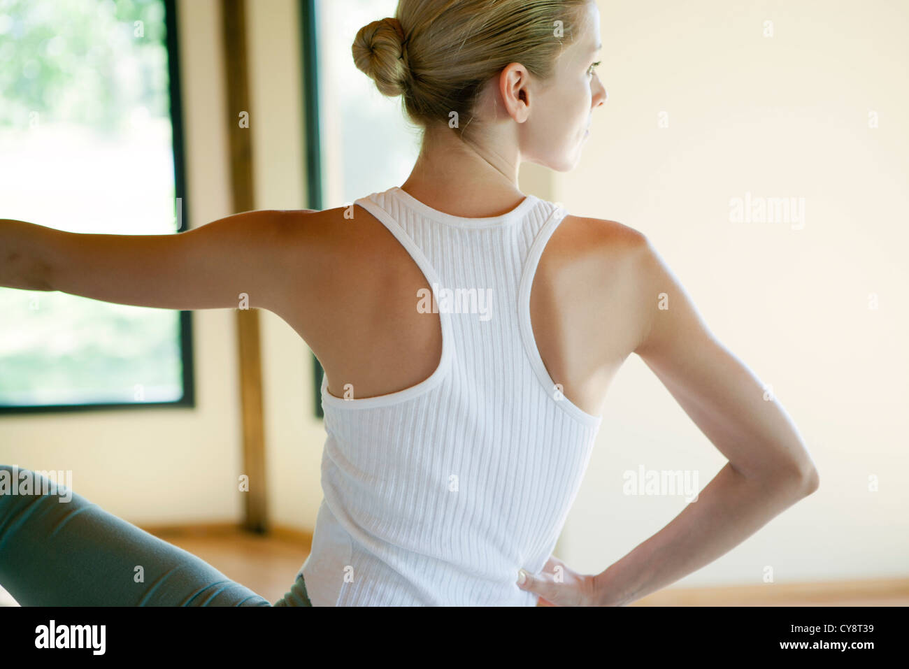 Young woman doing seated spinal twist, rear view Stock Photo - Alamy