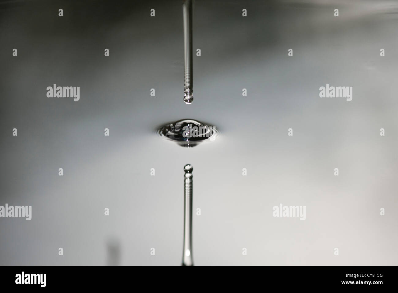 Drop hitting smooth surface of water Stock Photo - Alamy