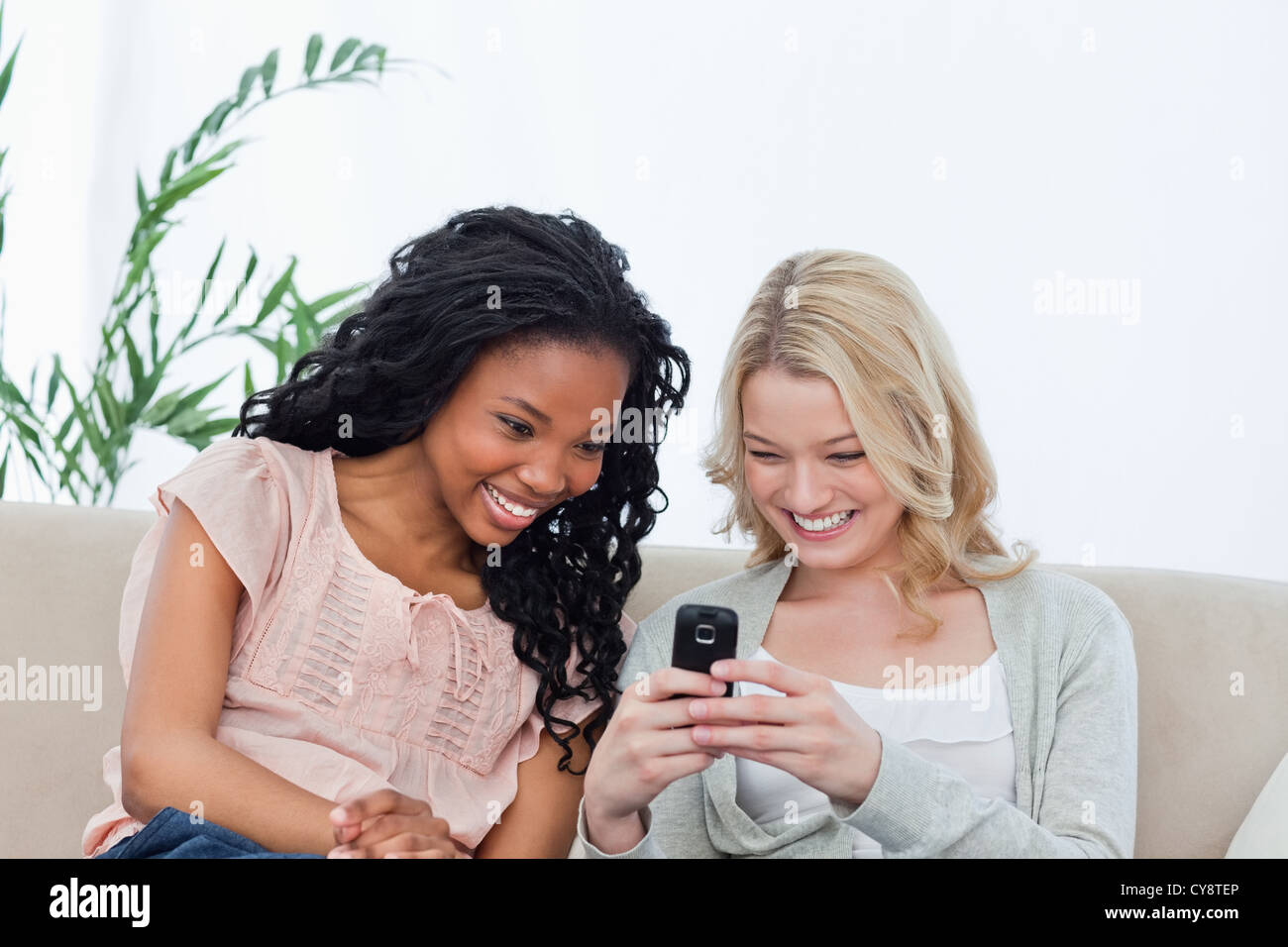 A woman is showing her friend her mobile phone Stock Photo - Alamy
