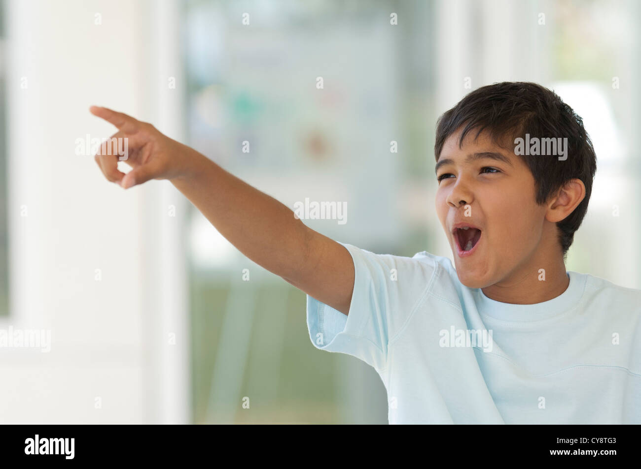 Boy pointing out of frame, surprised expression on face Stock Photo - Alamy