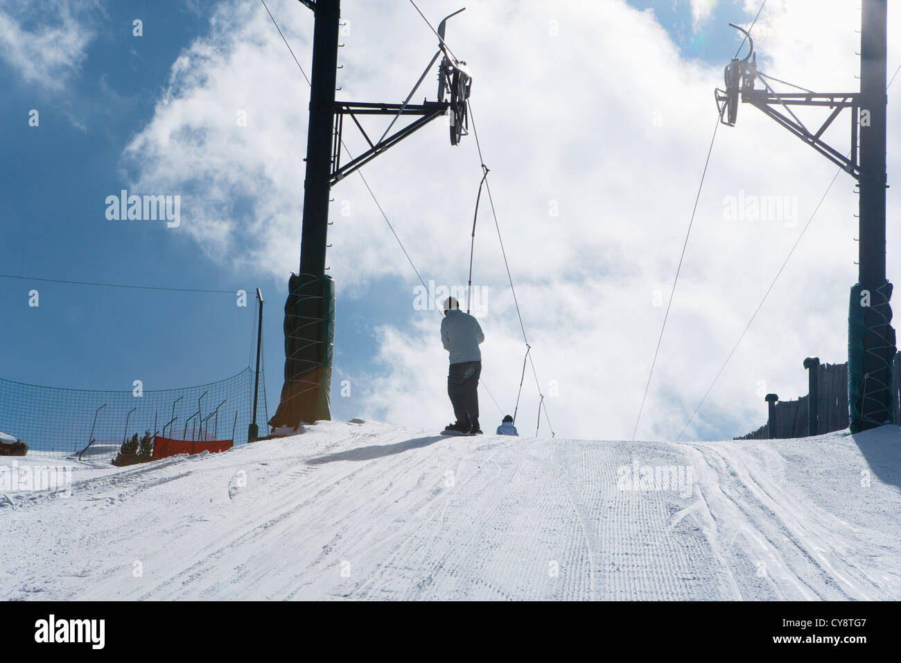 Skier riding ski lift, rear view Stock Photo - Alamy