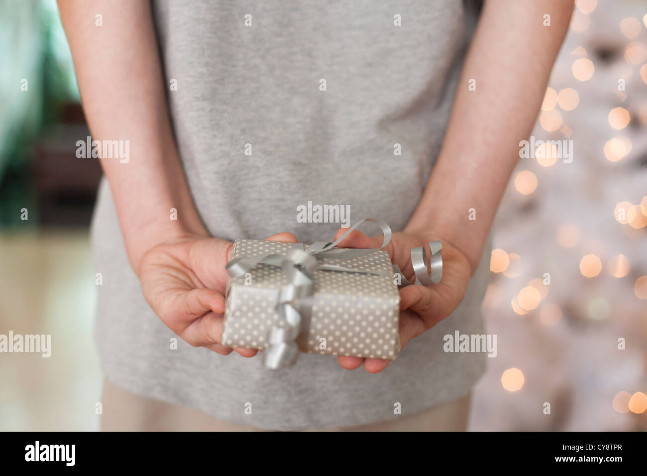 Girl holding gift behind back Stock Photo - Alamy