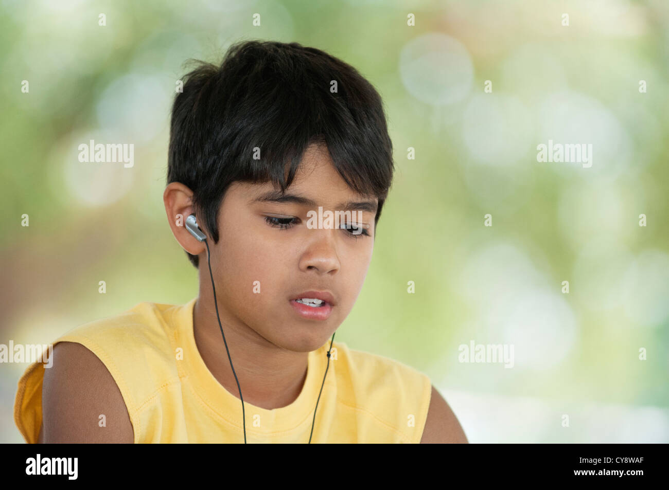 Boy listening to earphones Stock Photo - Alamy