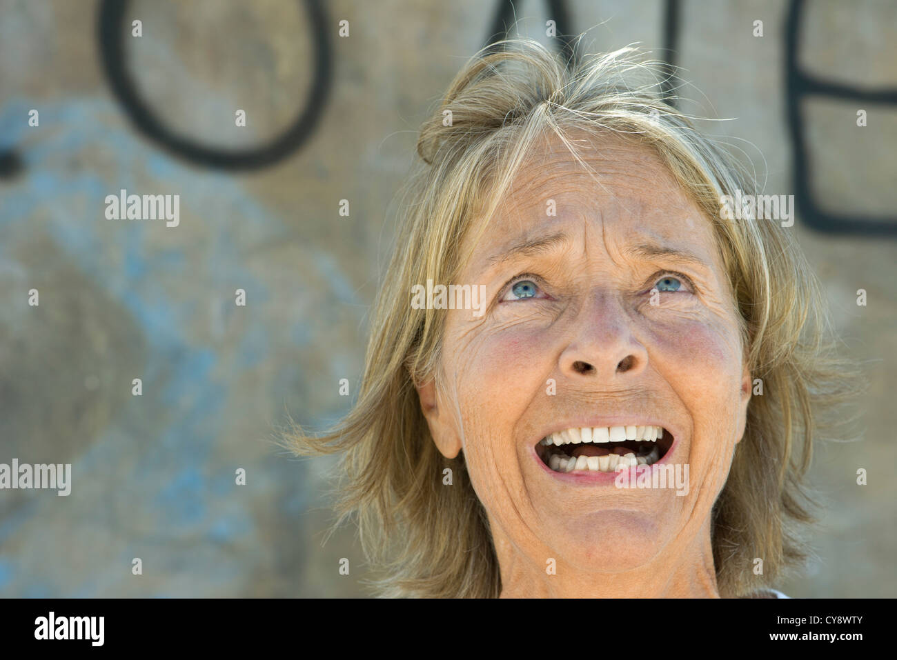 Senior woman looking up with fearful expression on face Stock Photo - Alamy