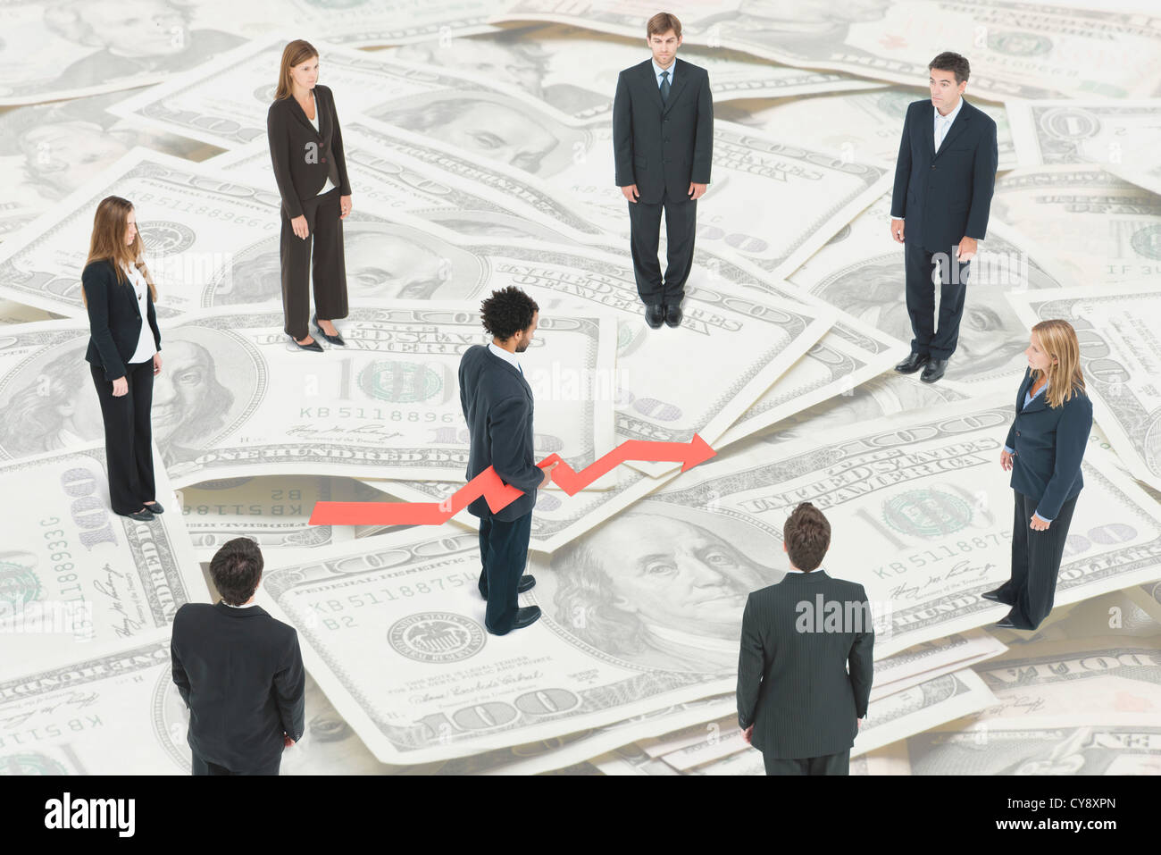 Executives standing on large pile of money around man holding arrow ...