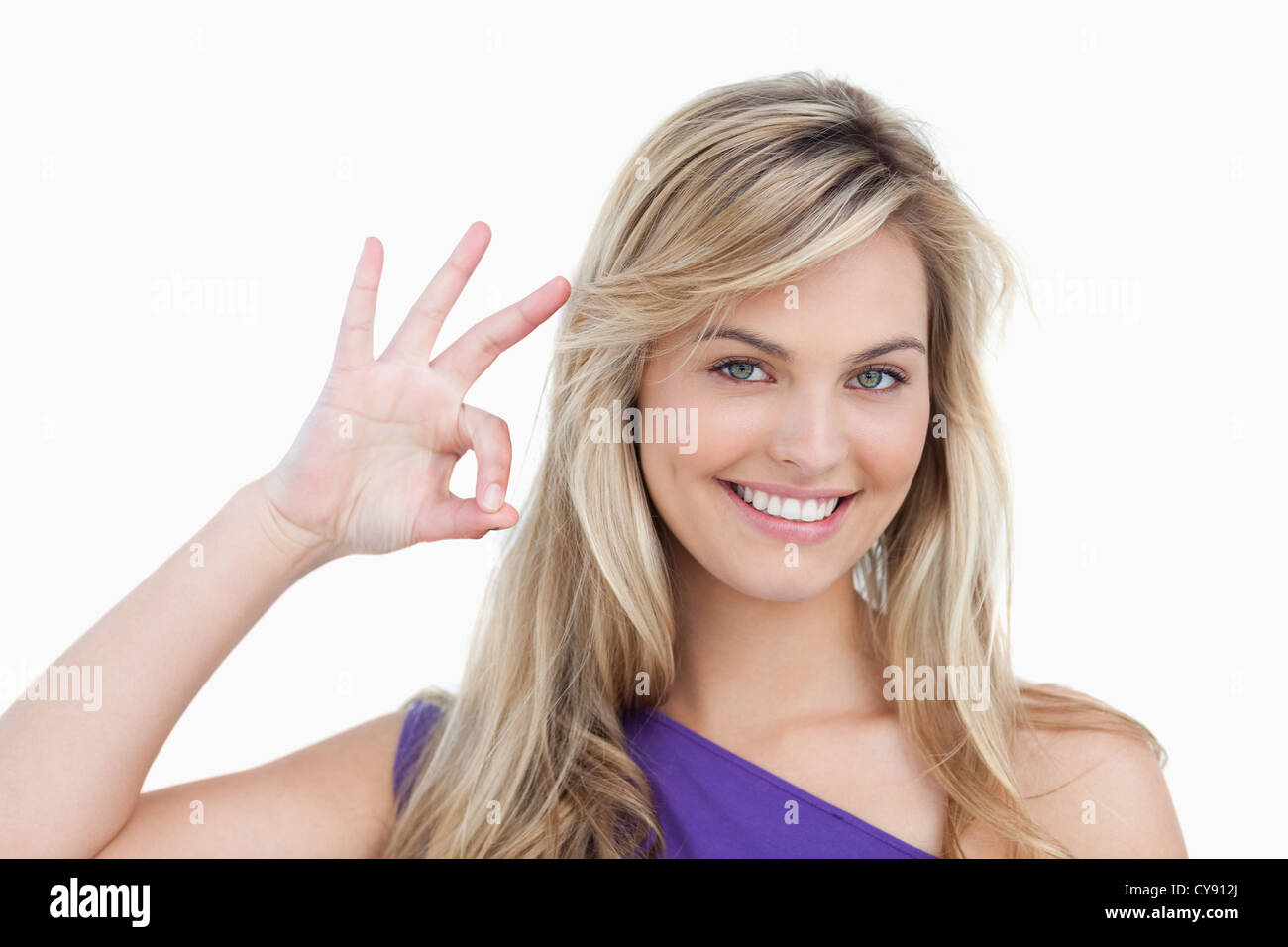 Smiling young blonde woman making the ok sign Stock Photo - Alamy