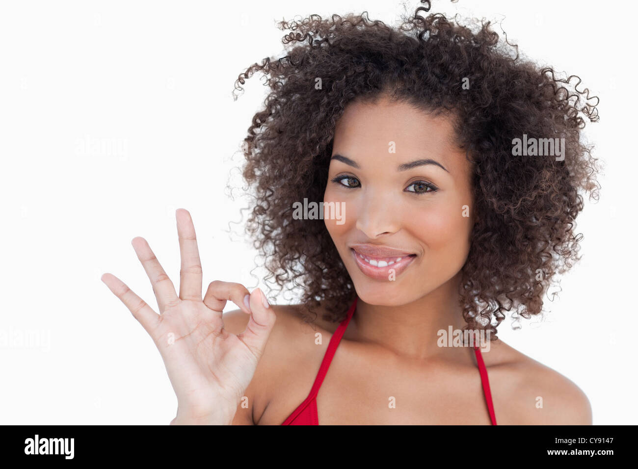 Smiling young woman showing the ok sign Stock Photo - Alamy