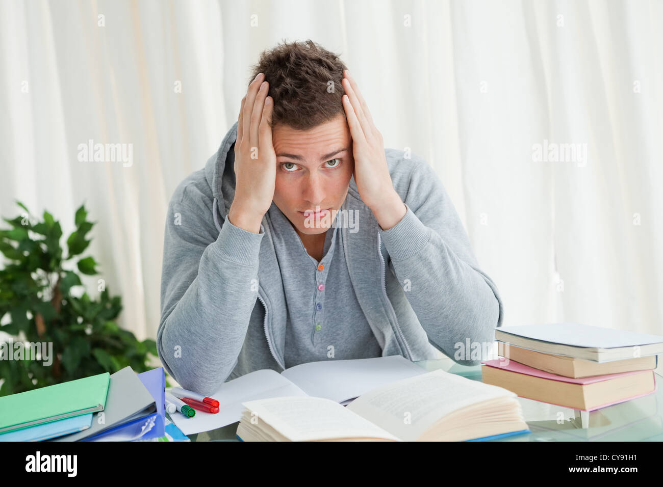 Portrait of a distressed student doing his homeworks Stock Photo - Alamy