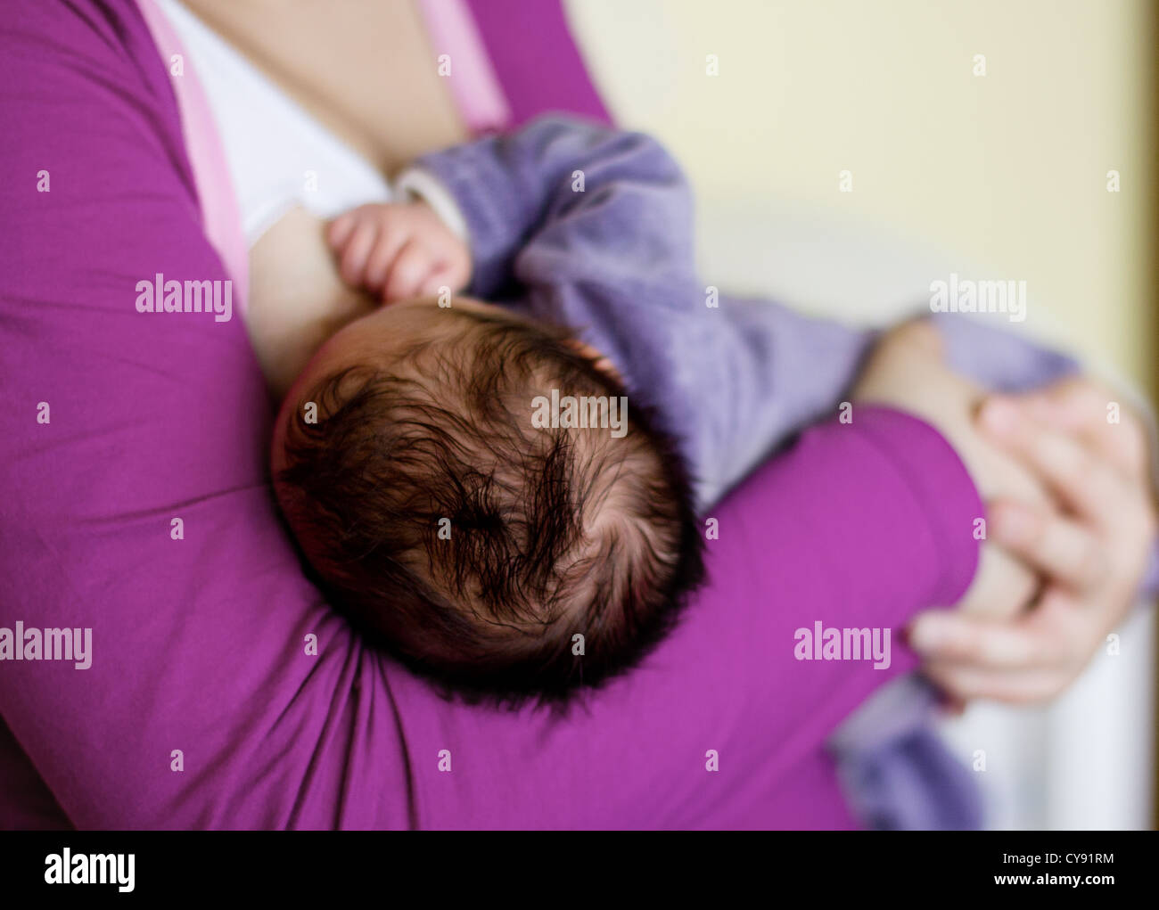 Mother holding and feeding newborn baby,rear view Stock Photo - Alamy
