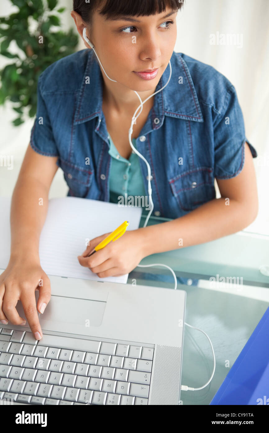 Female student looking away while doing her homework Stock Photo - Alamy