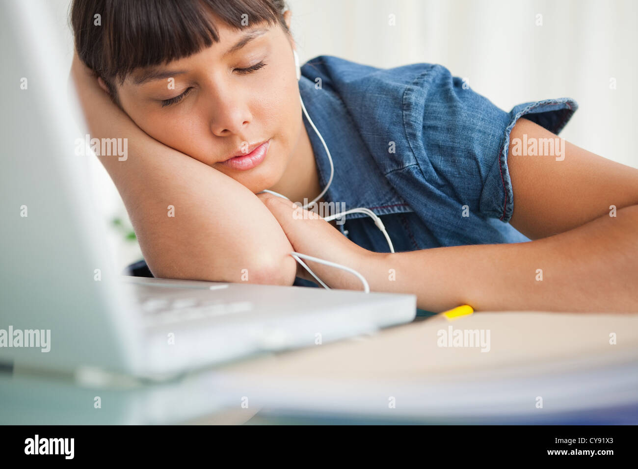 Tired female student enjoying music Stock Photo - Alamy