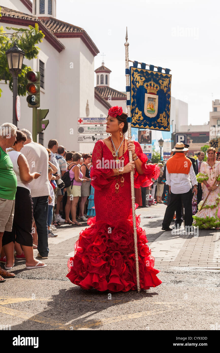A woman follows a Religious Procession in Fuengirola. Spain. Carrying a ...