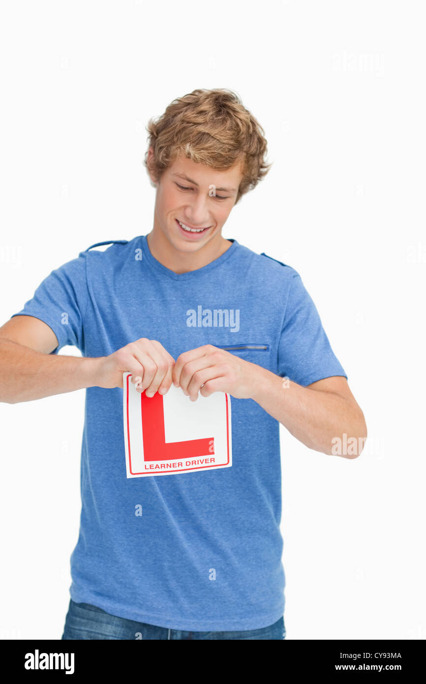 Young man ripping a learner driver sign Stock Photo - Alamy