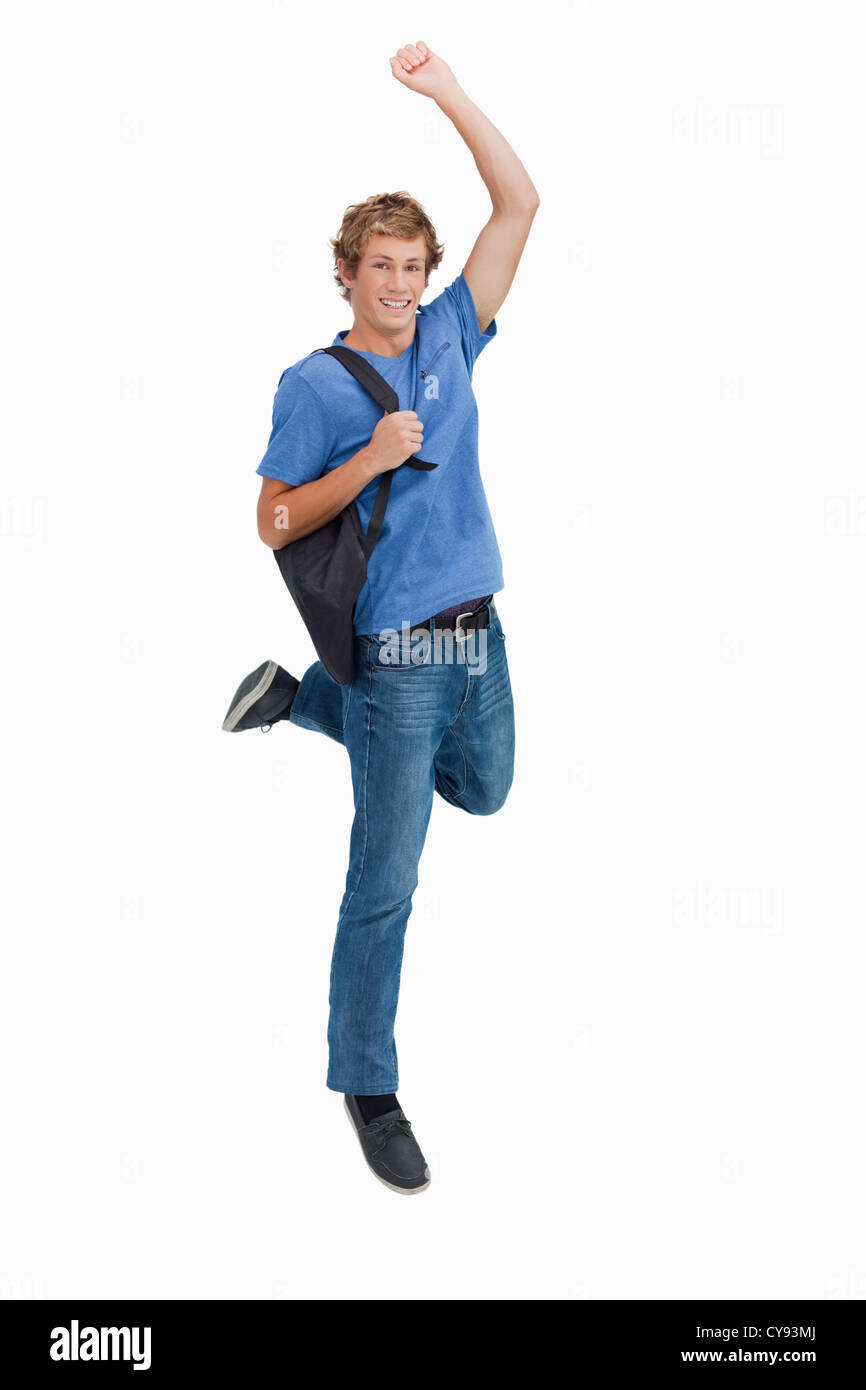 Young blond man jumping with a backpack Stock Photo - Alamy