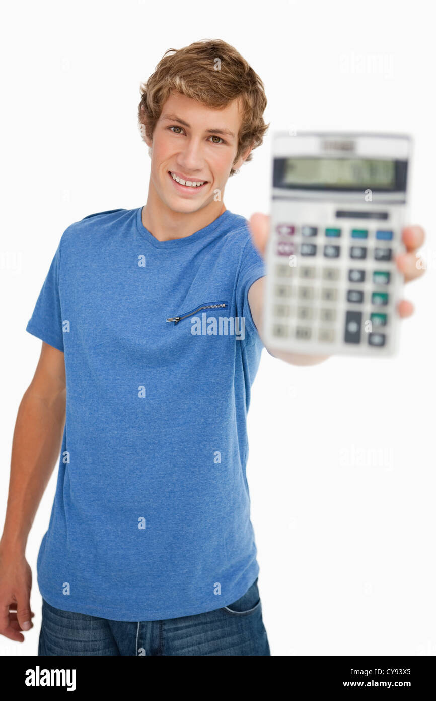 Smiling young man showing a calculator Stock Photo - Alamy