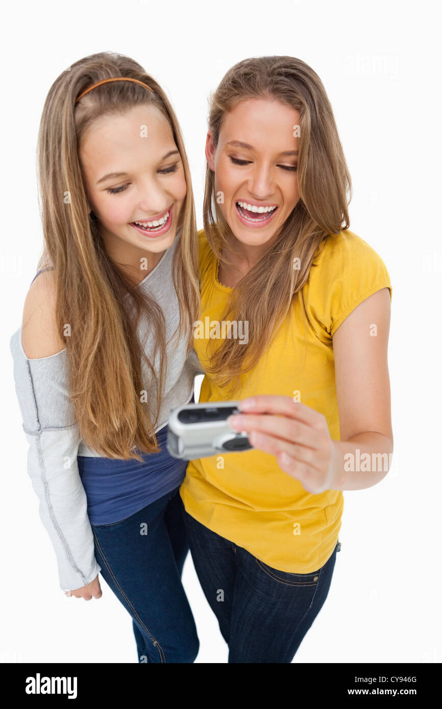 Two friends laughing while checking their picture on a digital camera ...