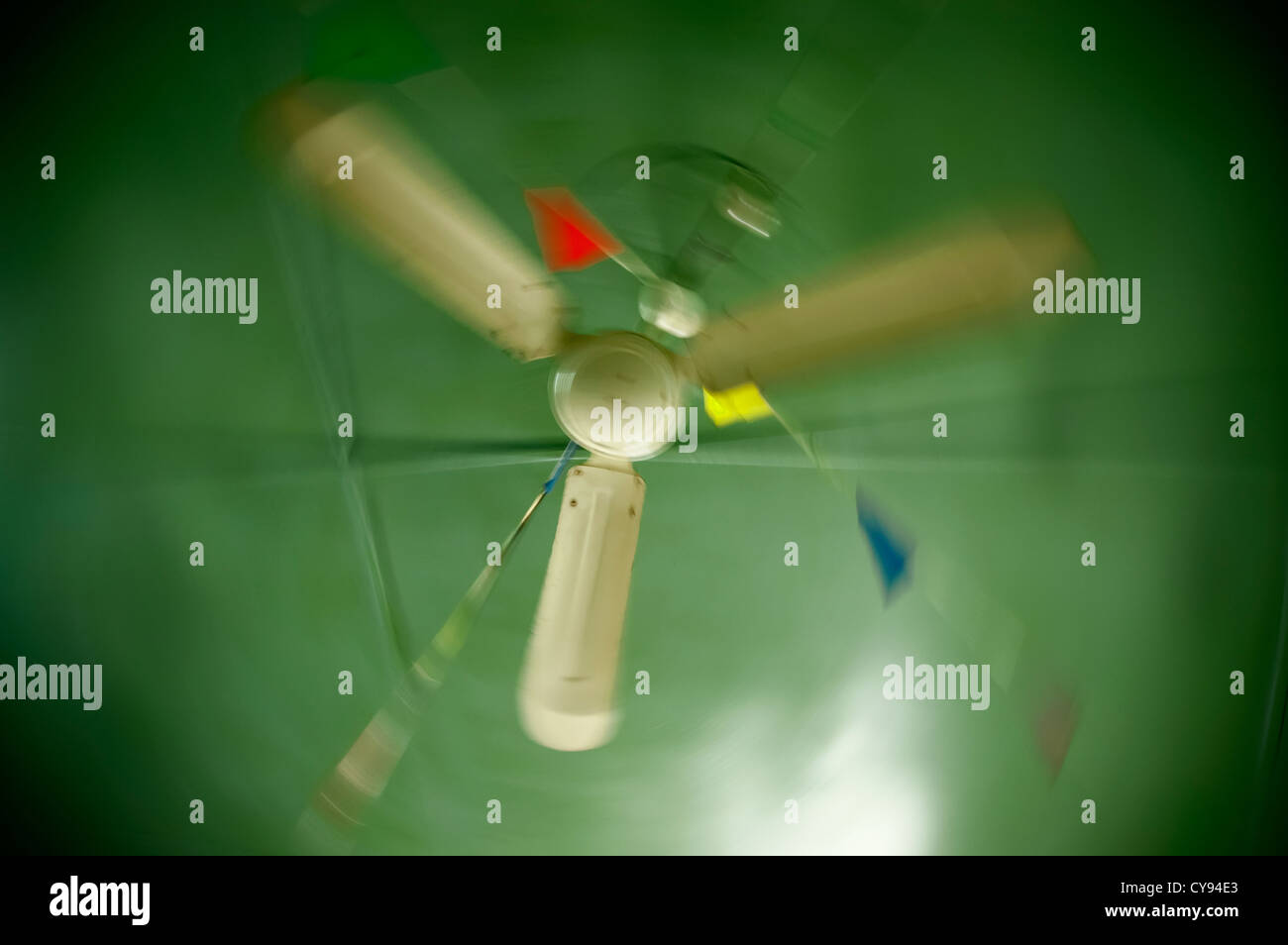 Old ceiling fan spinning in a cafe ceiling decorated with colorful ...