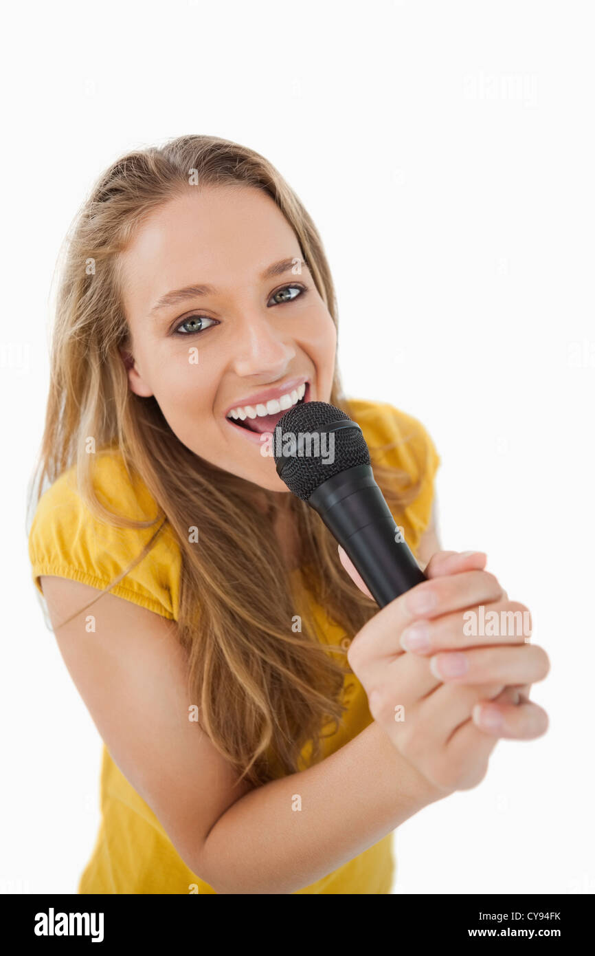 Close-up of a blonde singing with a microphone Stock Photo - Alamy