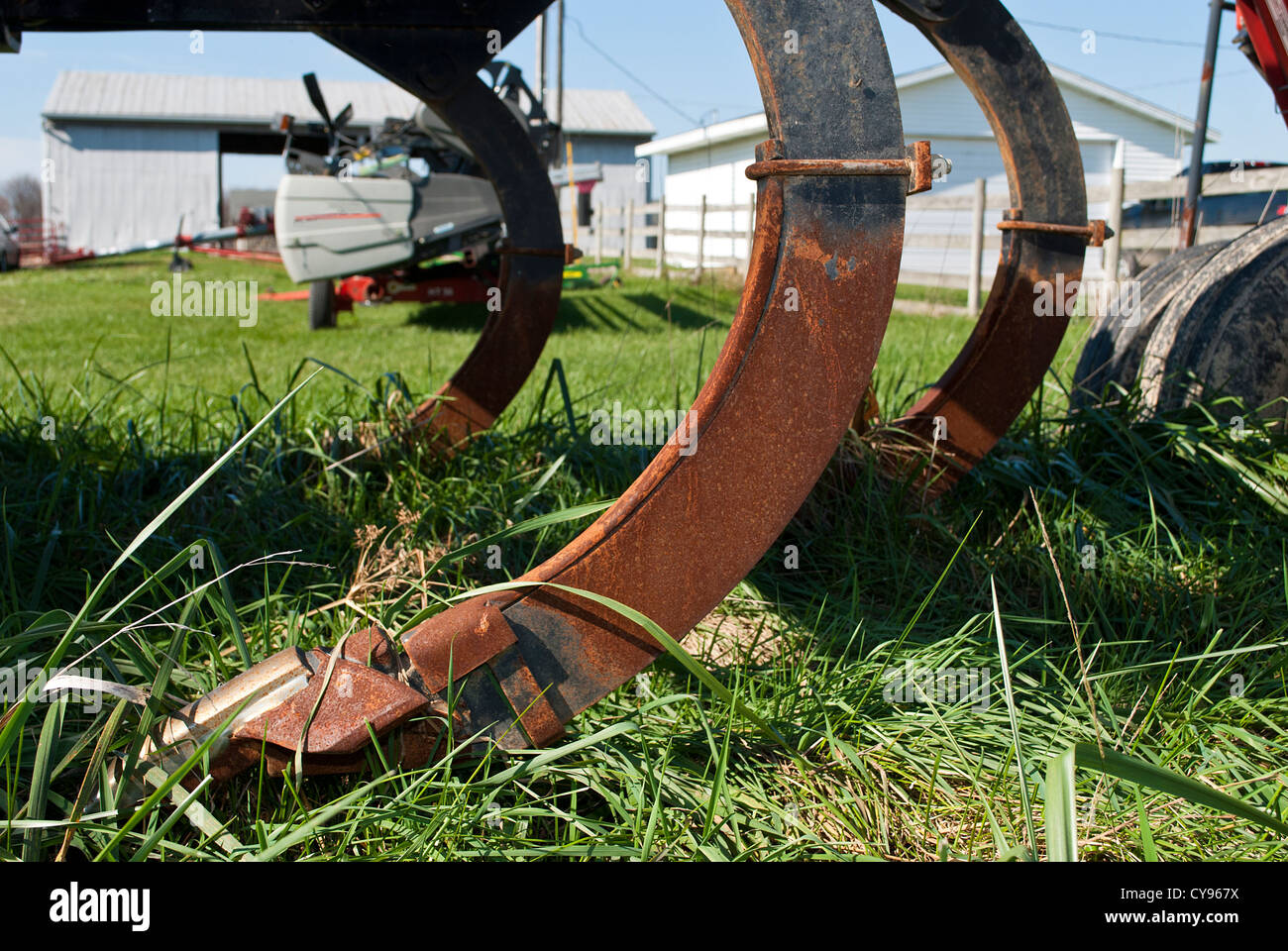 Plow tines wait out the off season in the barn yard Stock Photo - Alamy