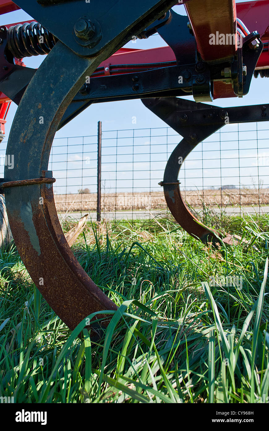 Plow tines overgrown by grass wait out the off season in the barnyard ...