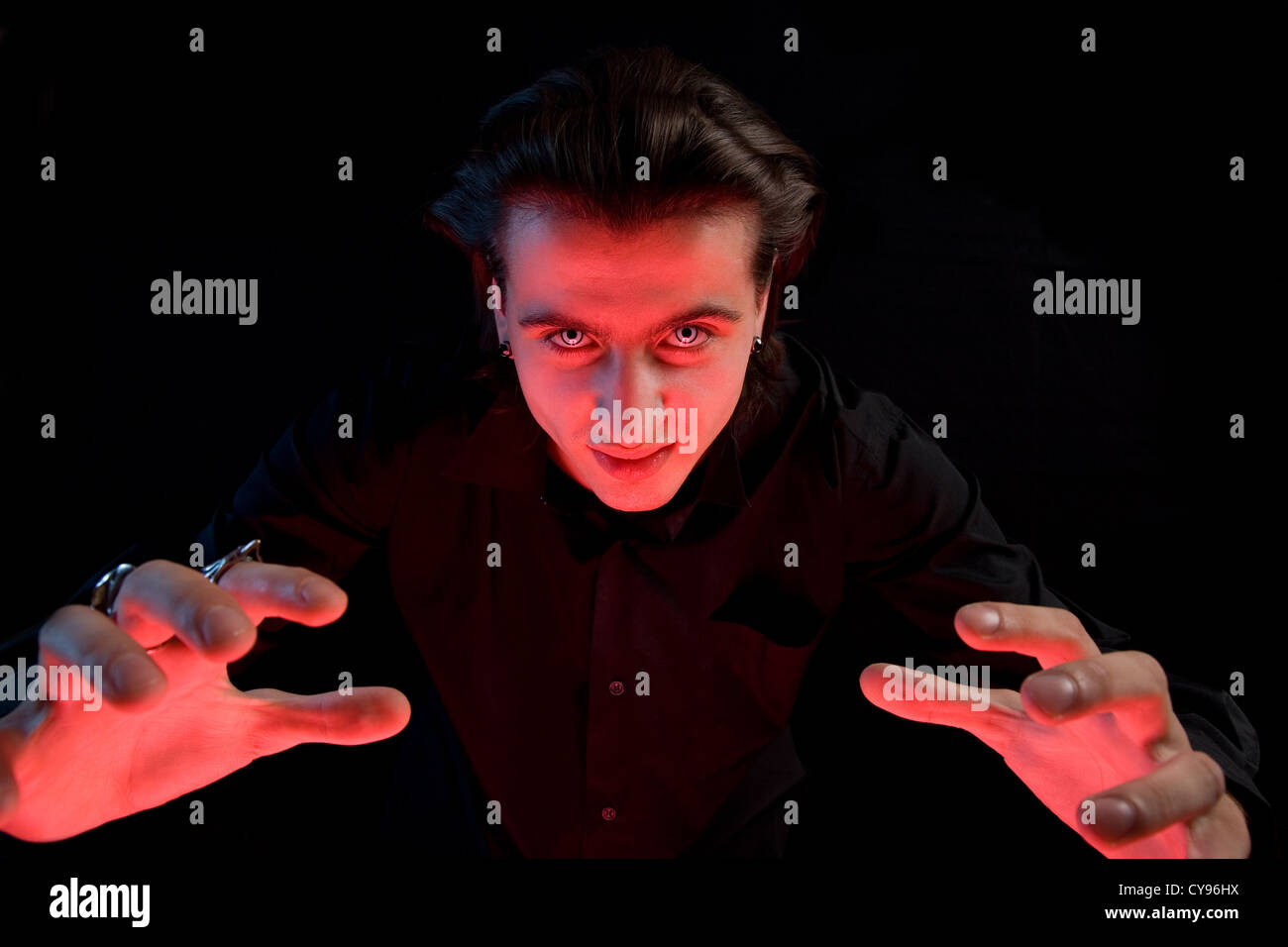 Scary vampire stretching his hands to catch a victim, isolated on black ...