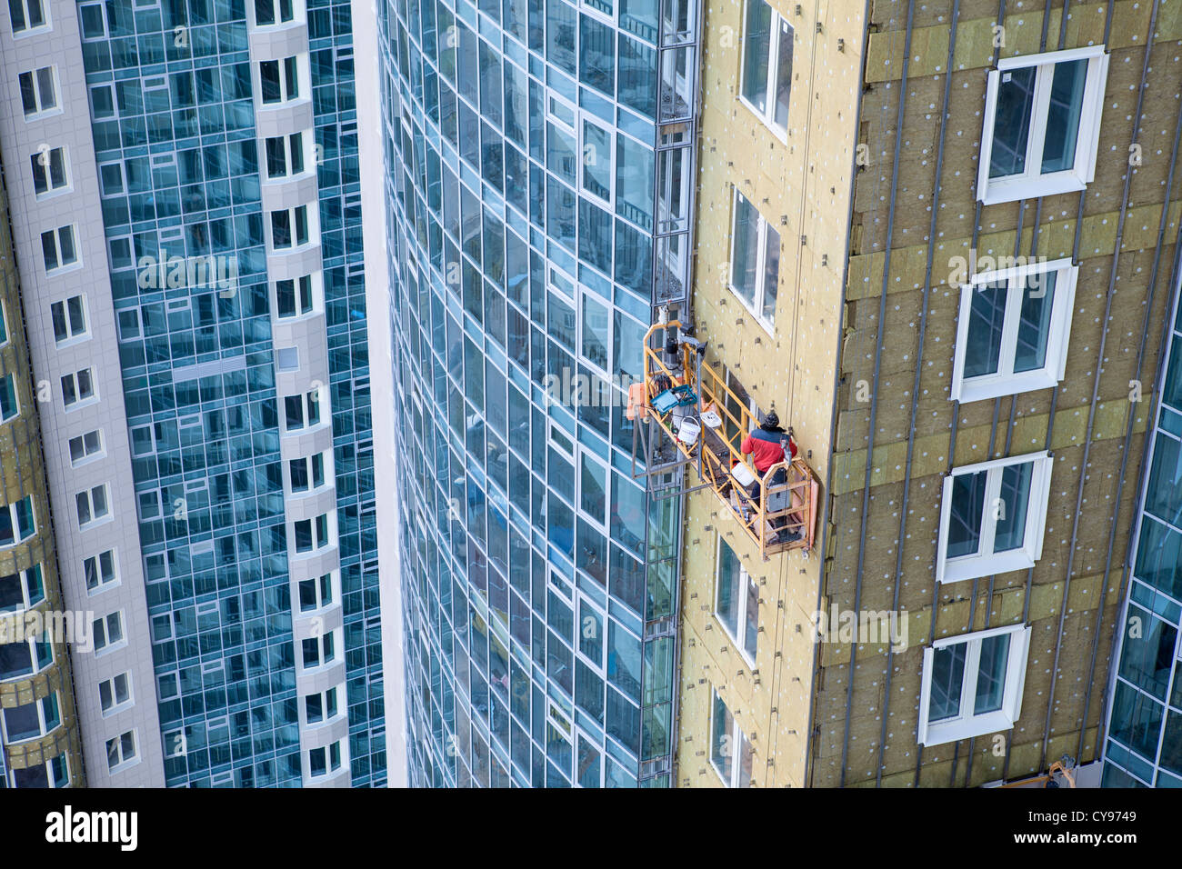 Construction platform with installers on the facade of the high-rise ...