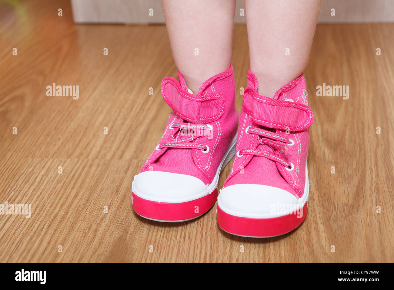 Children legs in pink shoes standing on the floor Stock Photo - Alamy