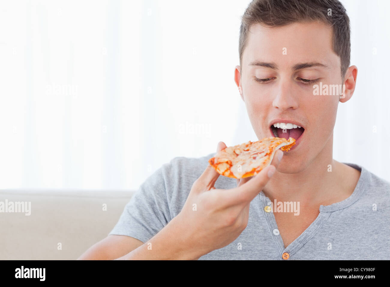 A man looking at the slice of pizza he is about to eat Stock Photo - Alamy