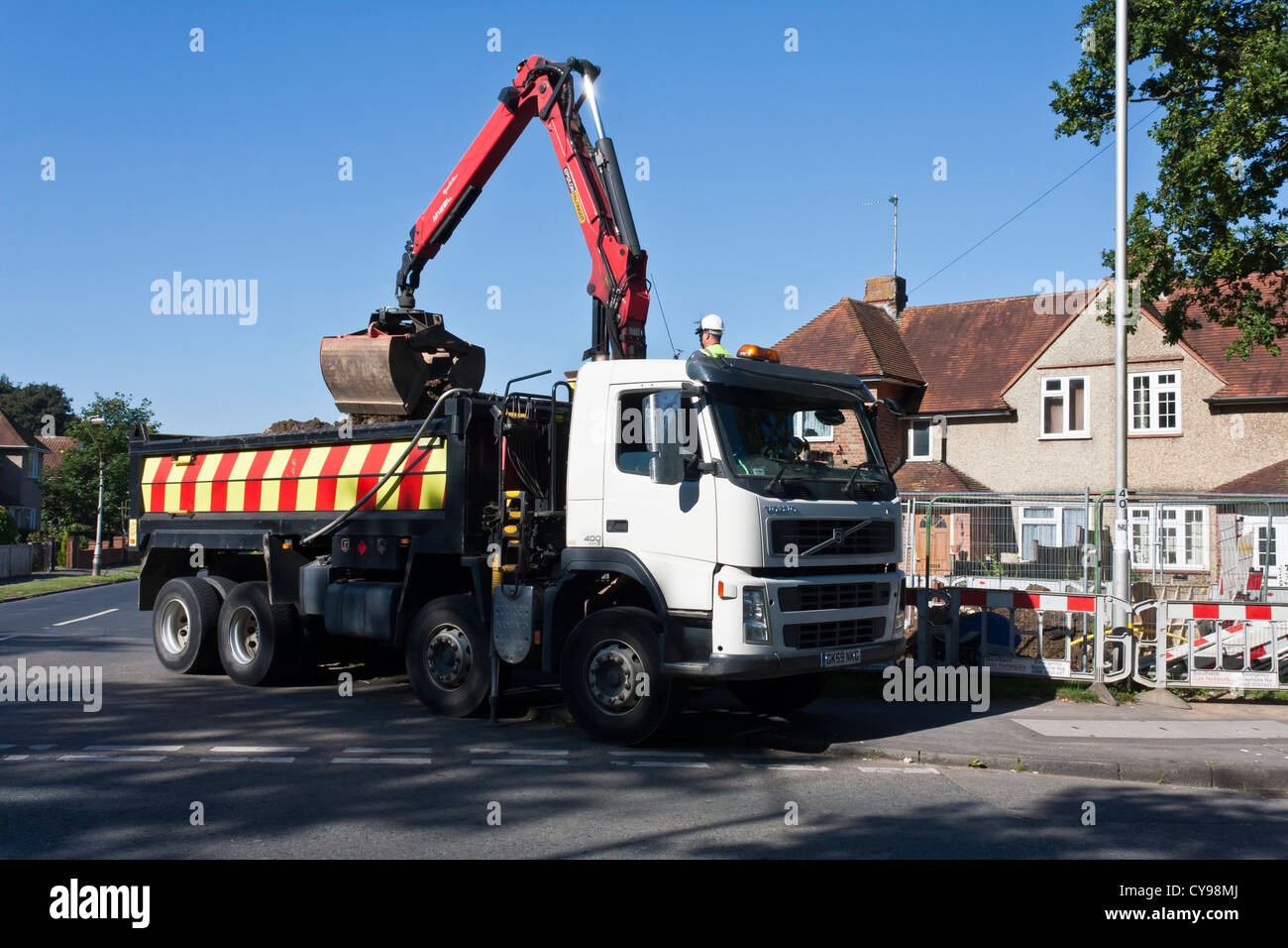 A dumper truck loads excavated soil from roadworks Stock Photo - Alamy