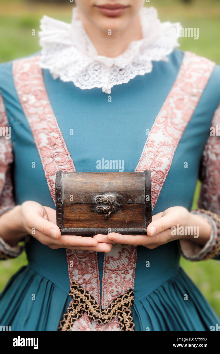 a lady in a renaissance dress holding a chest Stock Photo - Alamy