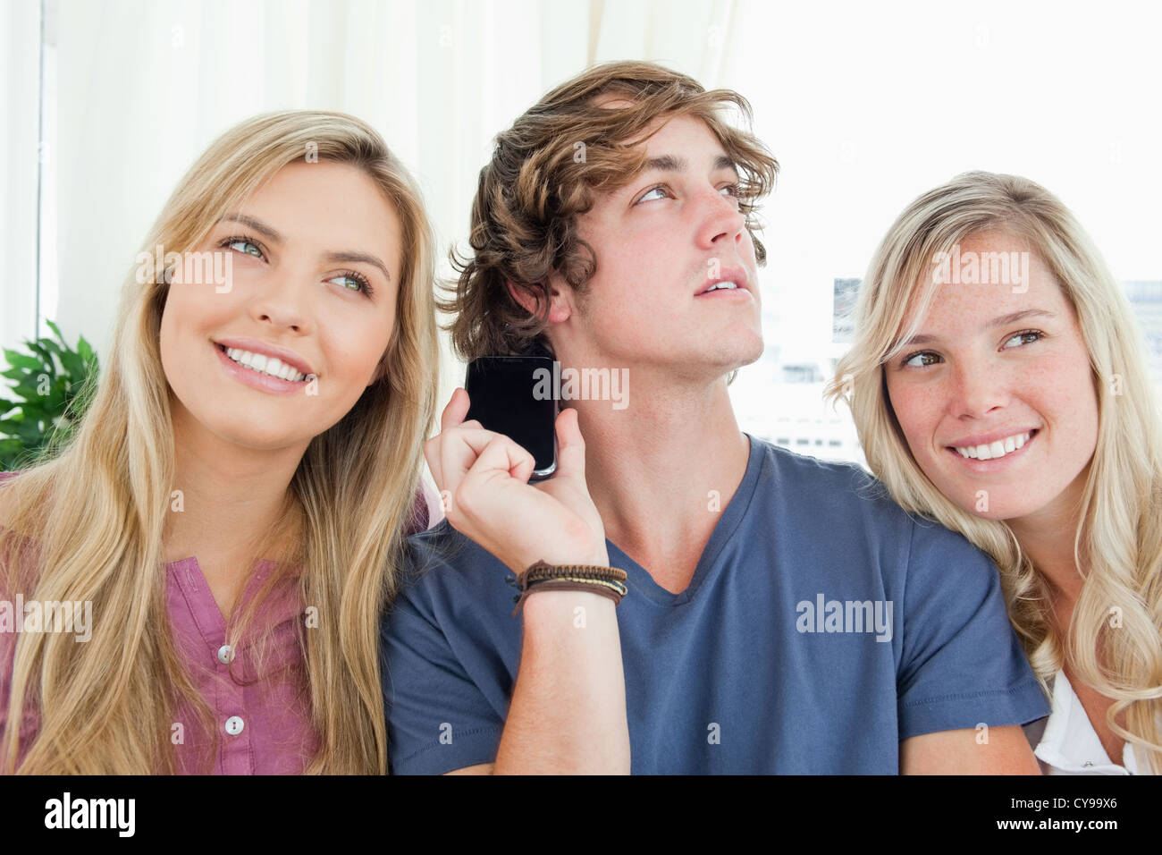 Three friends listening to a phone conversation Stock Photo - Alamy