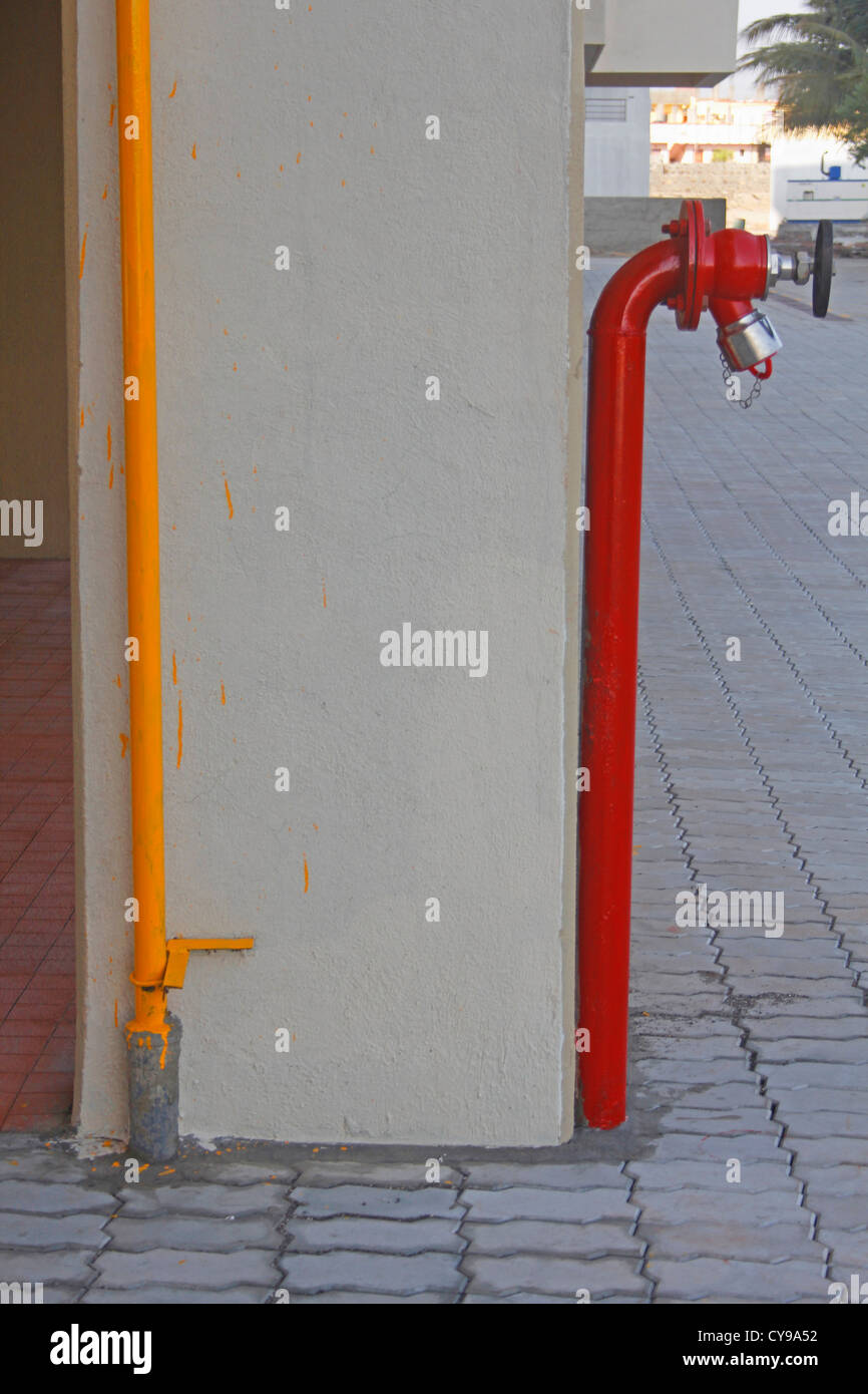 Red fire water lines in front of a building Stock Photo - Alamy