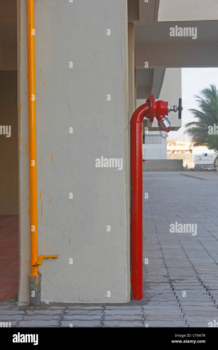 Red fire water lines in front of a building Stock Photo - Alamy