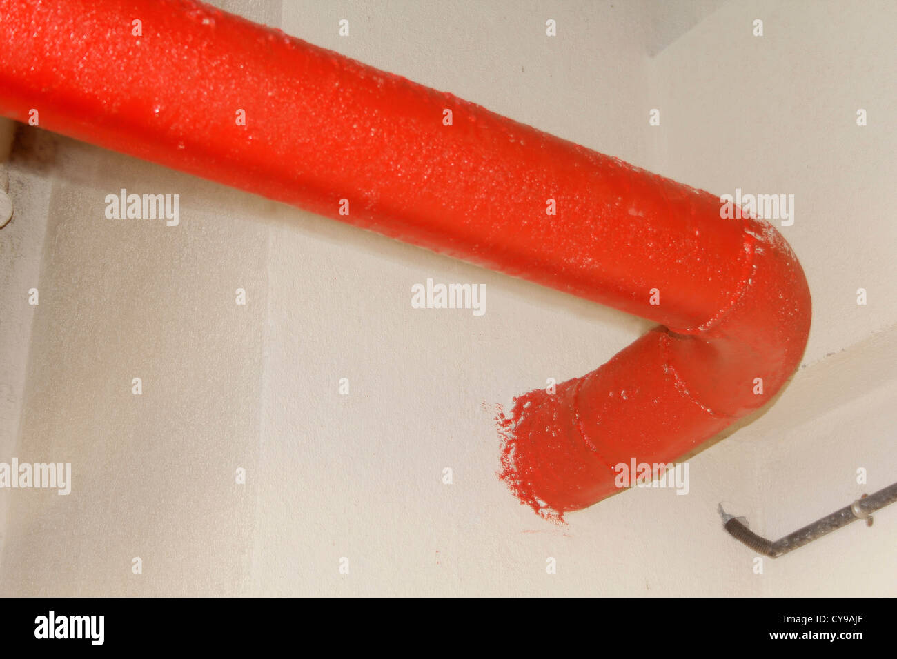 Red fire water lines in front of a building Stock Photo - Alamy