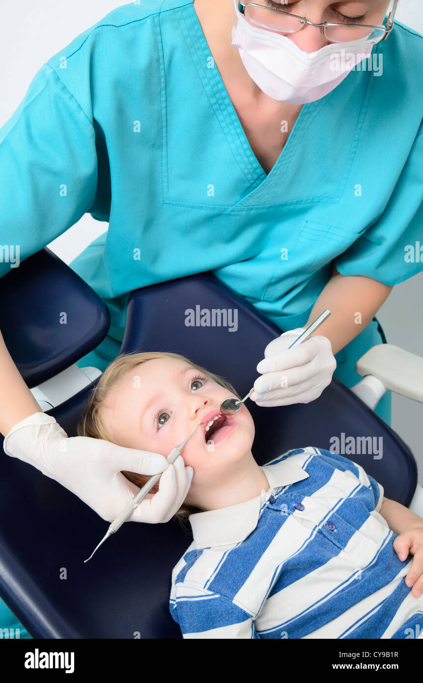 a dentist examining a kid with specialized instruments Stock Photo - Alamy