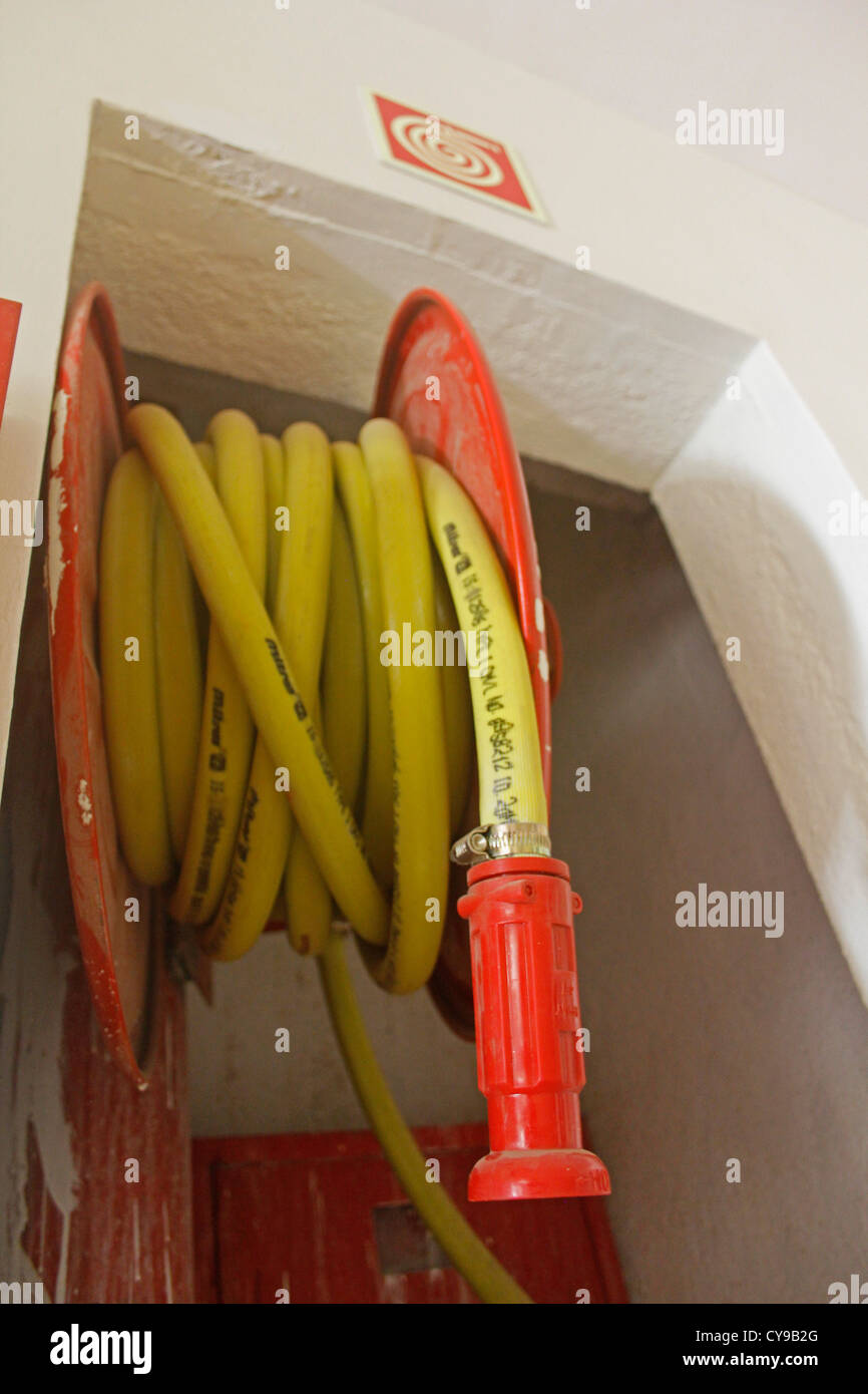 Red fire water lines in front of a building Stock Photo - Alamy