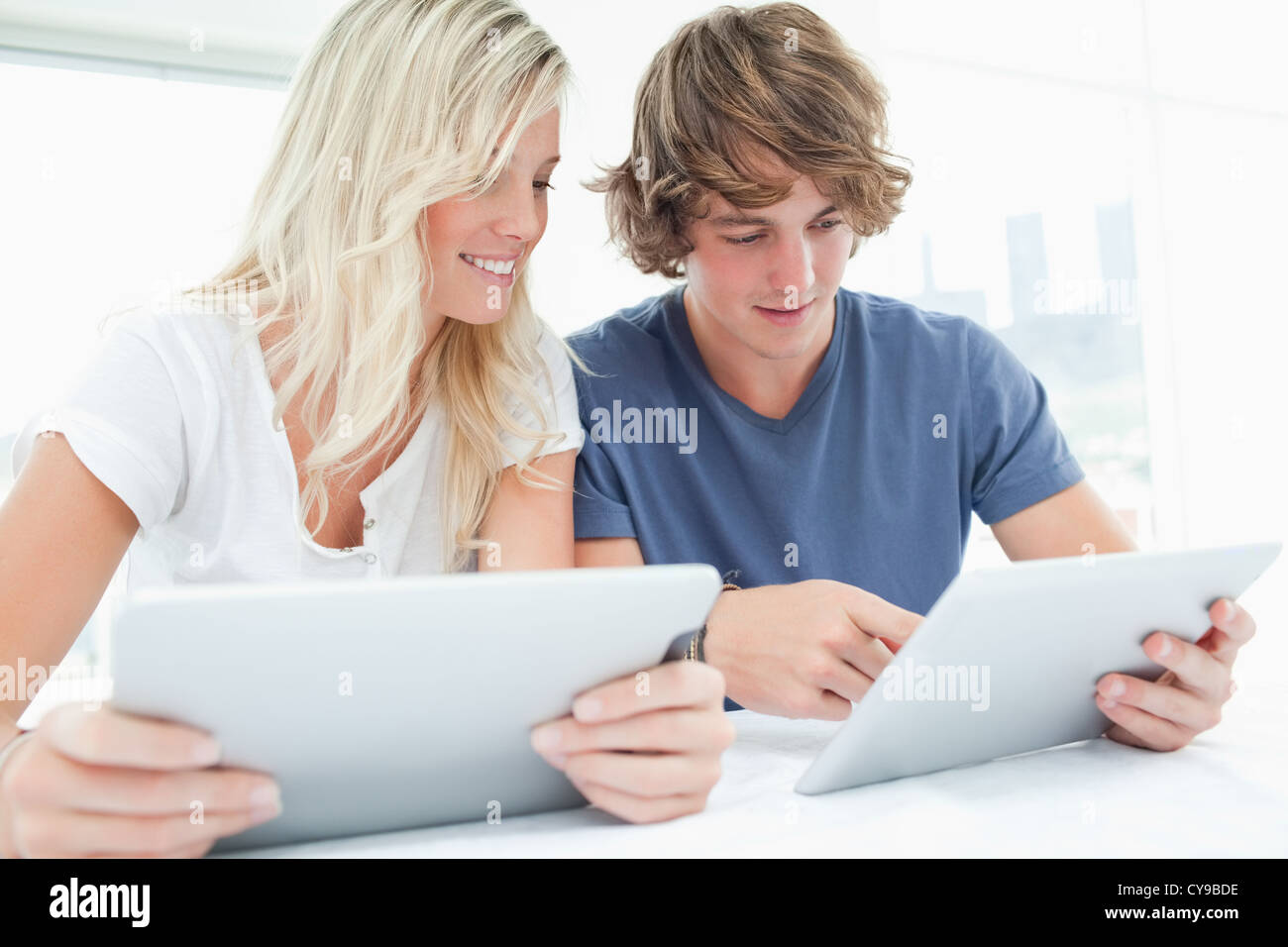 A couple both using tablets Stock Photo - Alamy