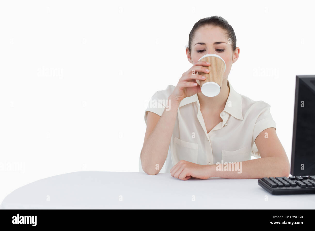 Businesswoman drinking a takeaway tea while using a computer Stock ...