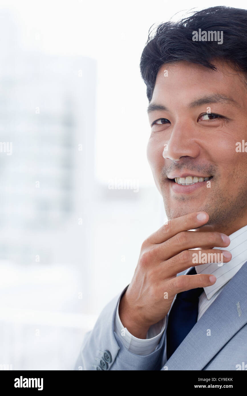 Portrait of a smiling office worker thinking Stock Photo - Alamy