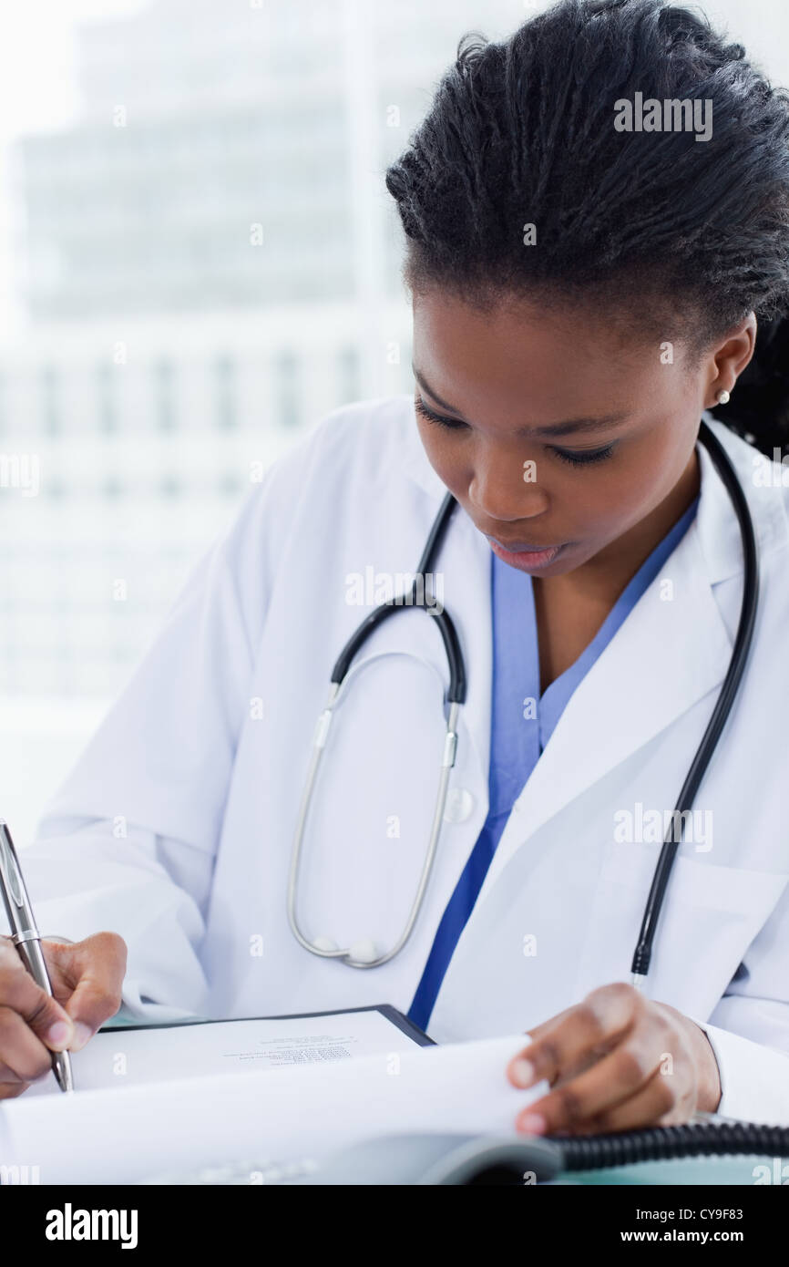 Portrait of a female doctor signing a document Stock Photo - Alamy