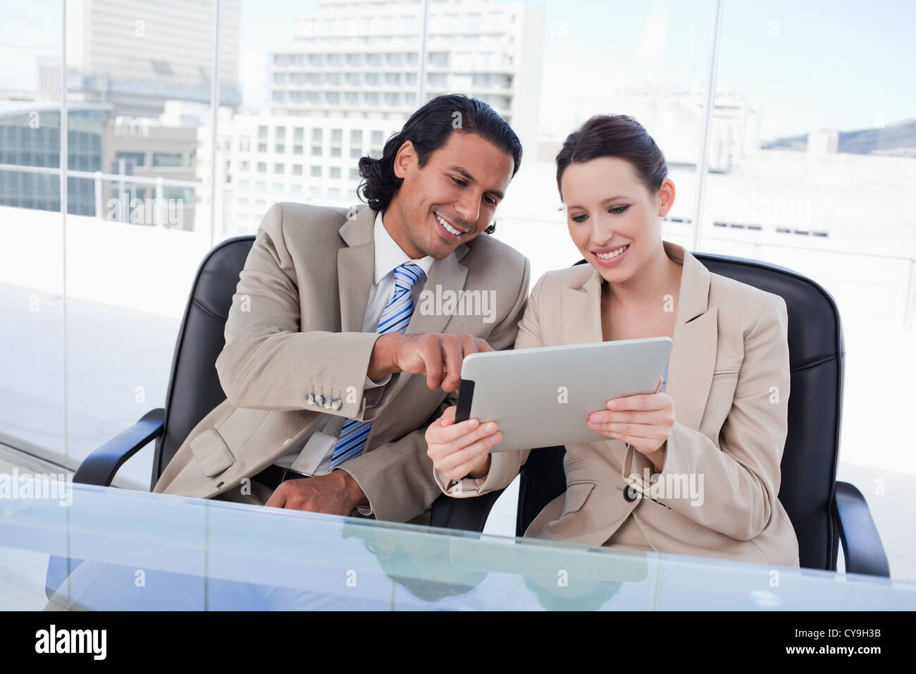 Happy business team using a tablet computer Stock Photo - Alamy