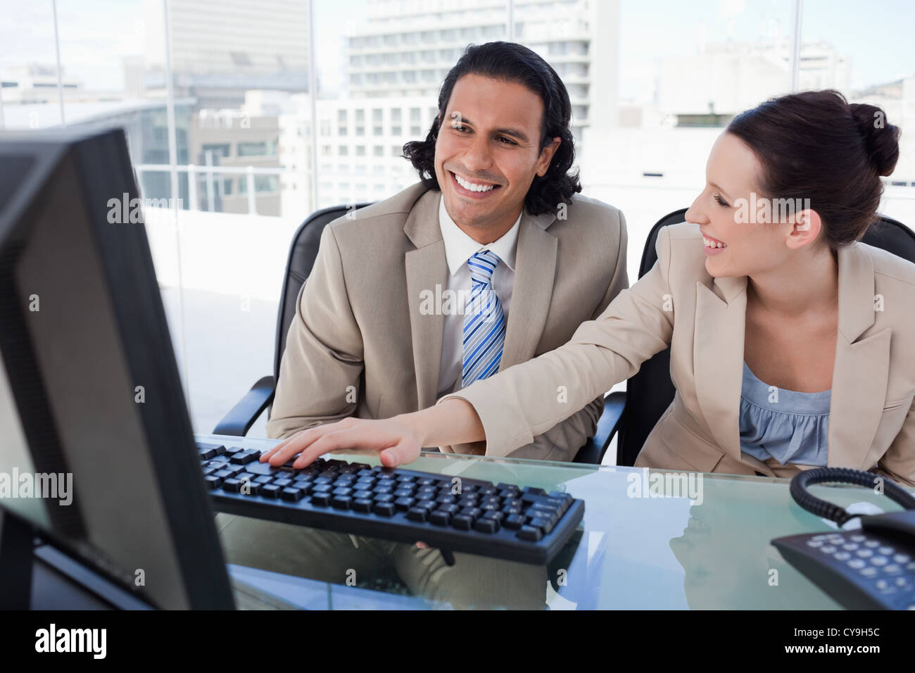 Happy business team using a computer Stock Photo - Alamy