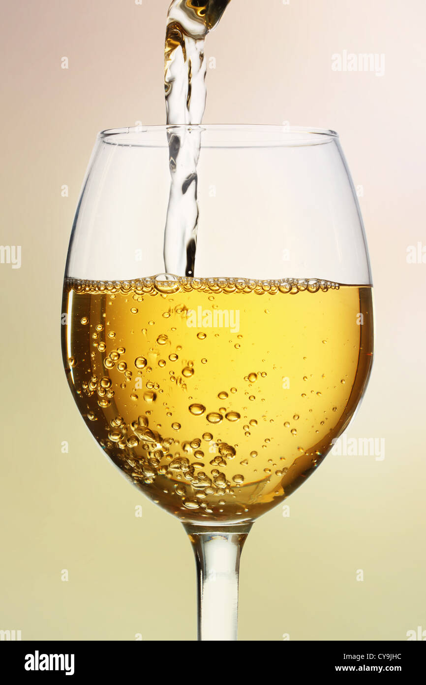 White wine being poured into a wine glass Stock Photo - Alamy
