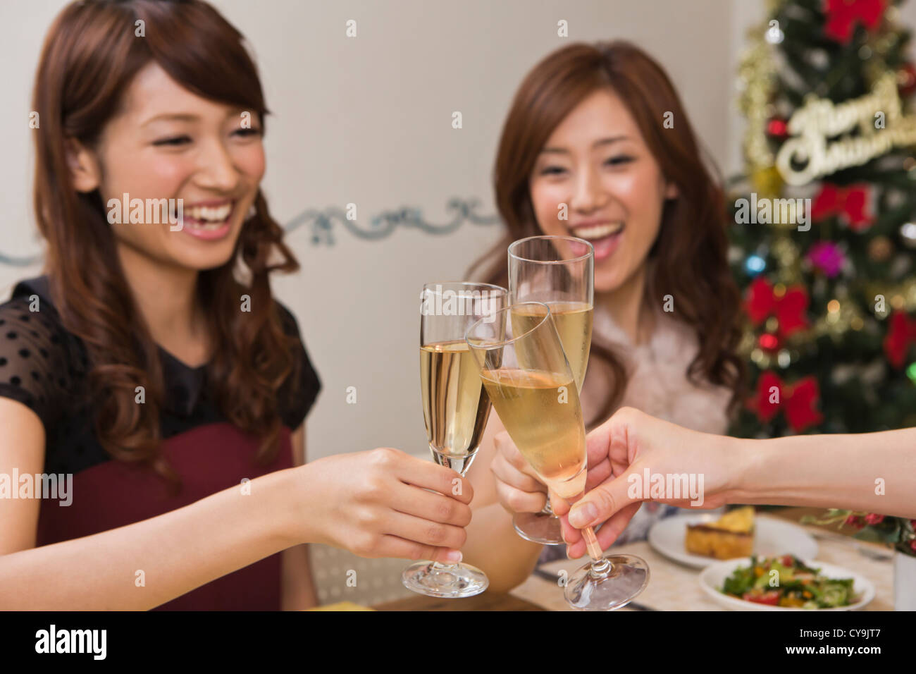 Three Young Women Toasting for Christmas Stock Photo - Alamy