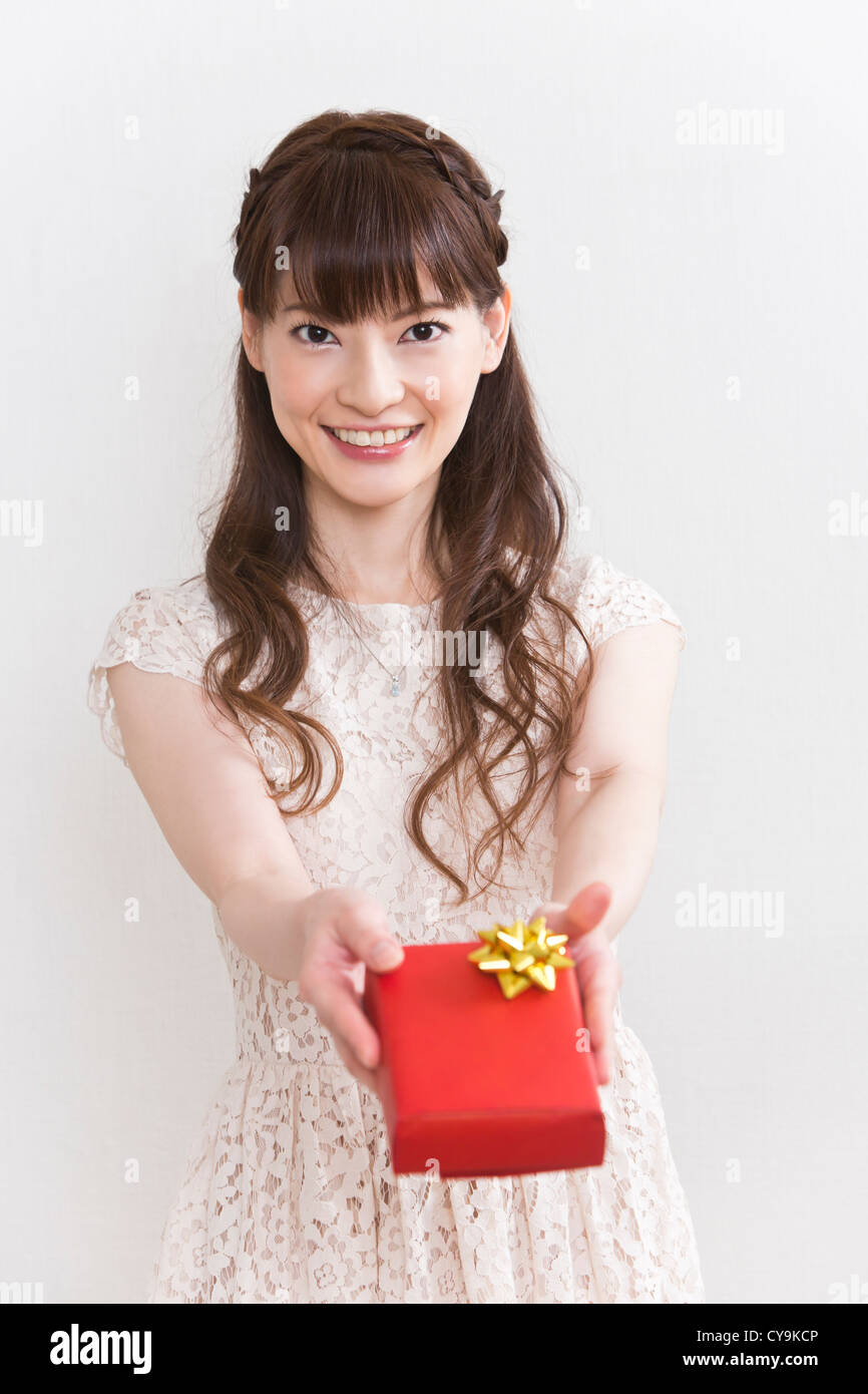 Three Young Women Presenting Gift Box Stock Photo - Alamy