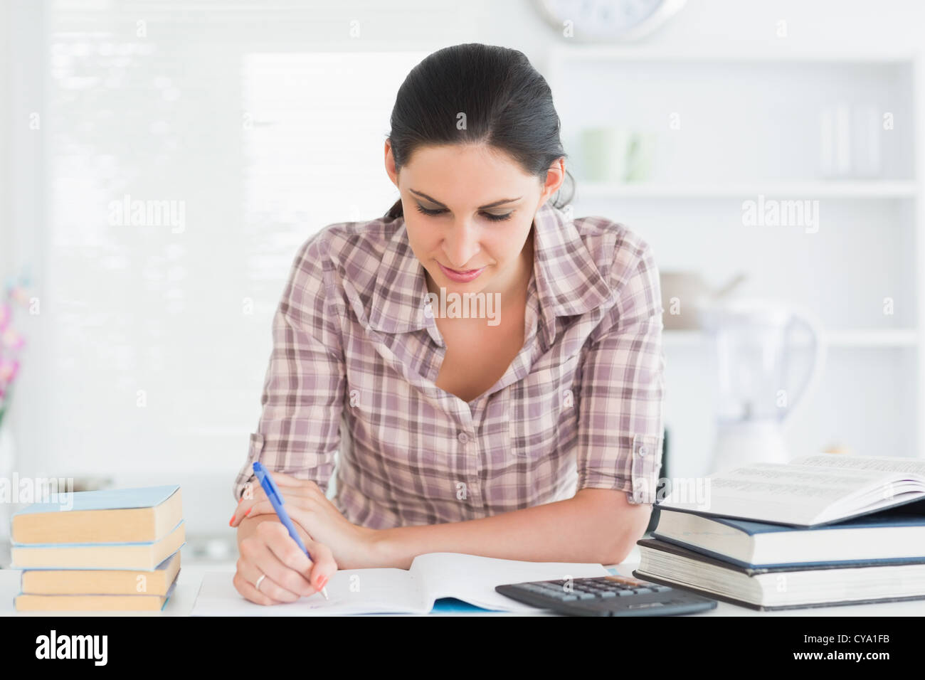 Front view of a woman writing on a notebook Stock Photo - Alamy