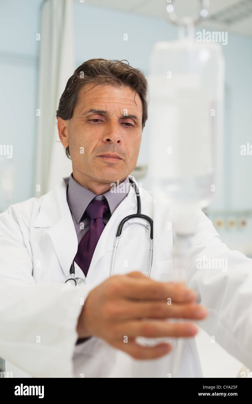 Thoughtful doctor in a hospital adjusting IV Stock Photo - Alamy