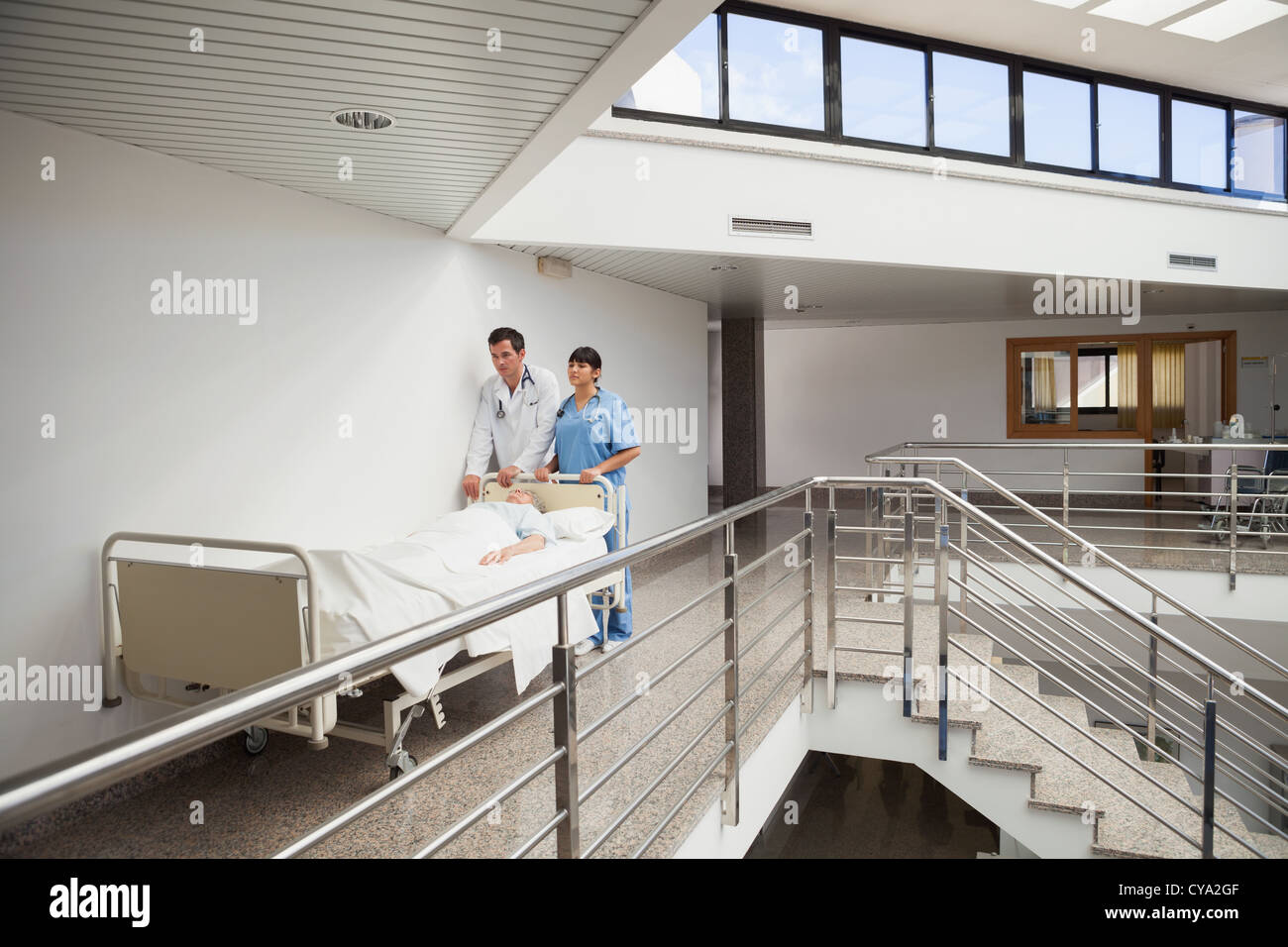 Doctor and nurse pushing patient in bed Stock Photo - Alamy