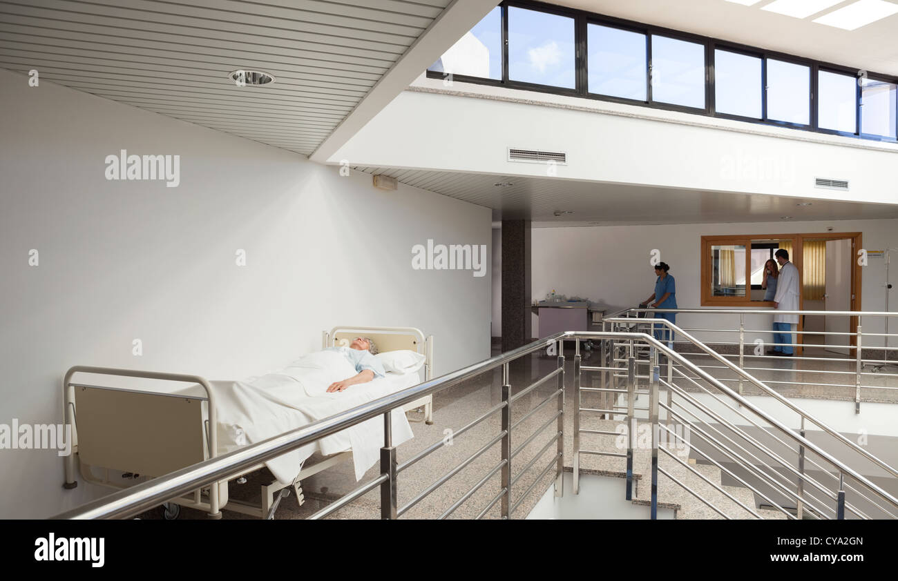 Patient lying in bed in corridor Stock Photo - Alamy