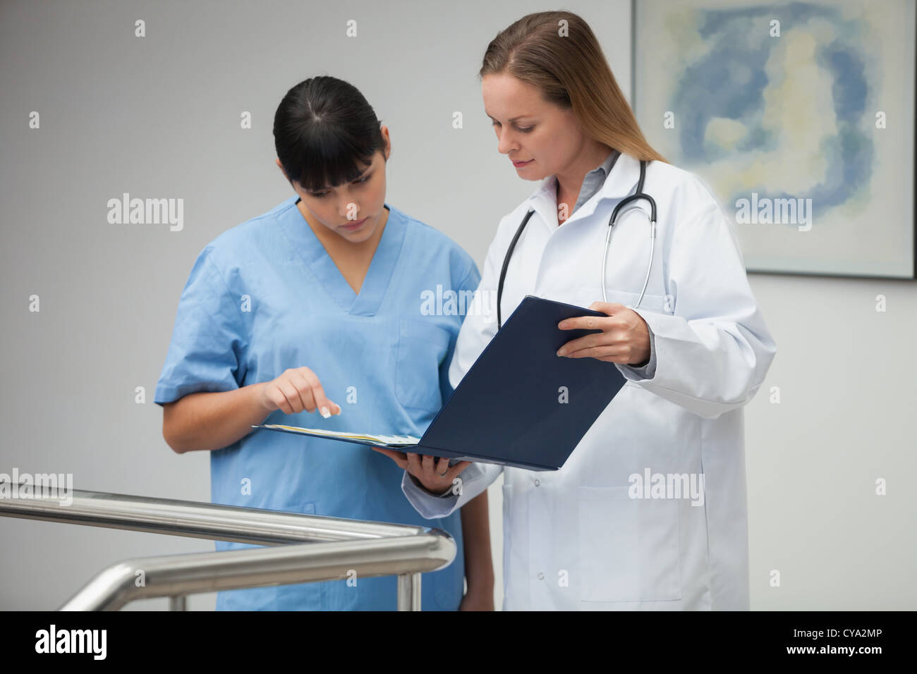 Female doctor explaining notes to nurse Stock Photo - Alamy